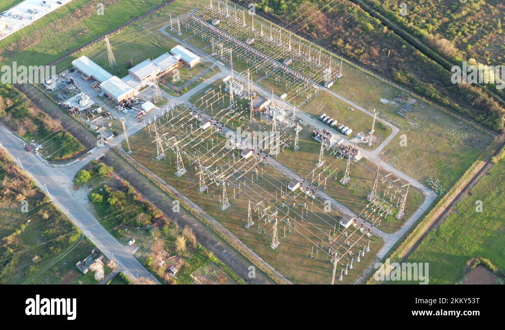 Electrical substation: transformers and grid of pylons, lines and wires ...