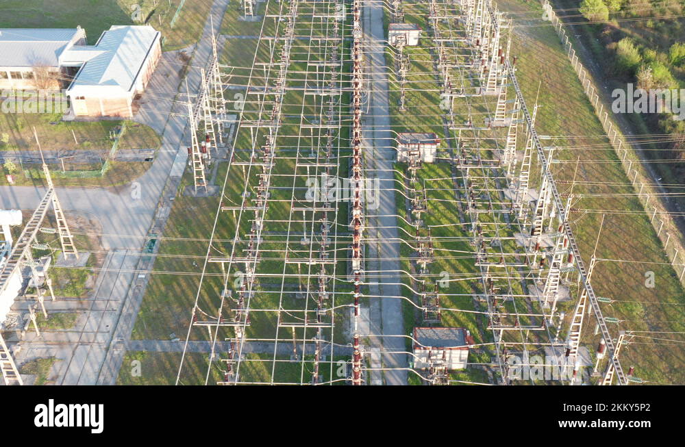 Electrical substation: transformers and grid of pylons, lines and wires ...