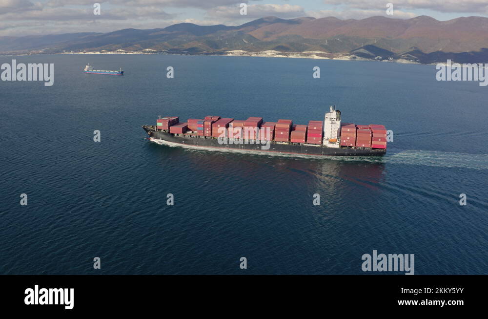 Ultra large container ship sailing at sea, aerial side view footage ...