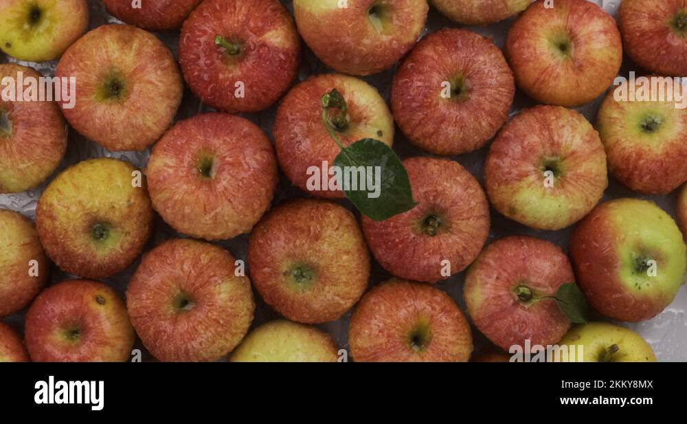 Rotation and zoom of a heap of apples. Raindrops falling on apples ...