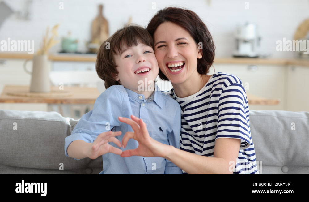 Mom and son make heart hand gesture together happy smiling look in ...