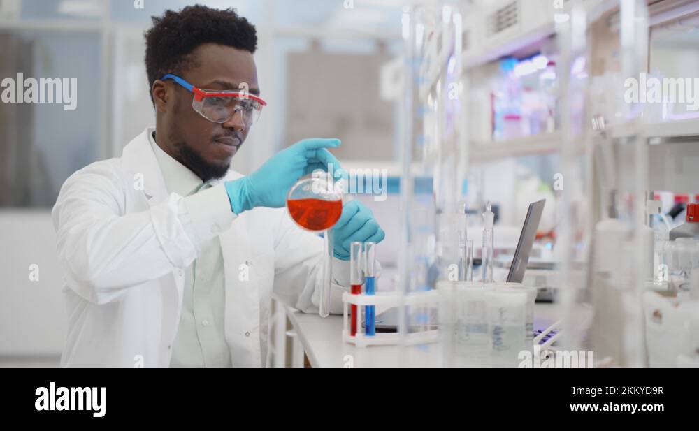 African chemistry researcher in sterile laboratory using modern ...