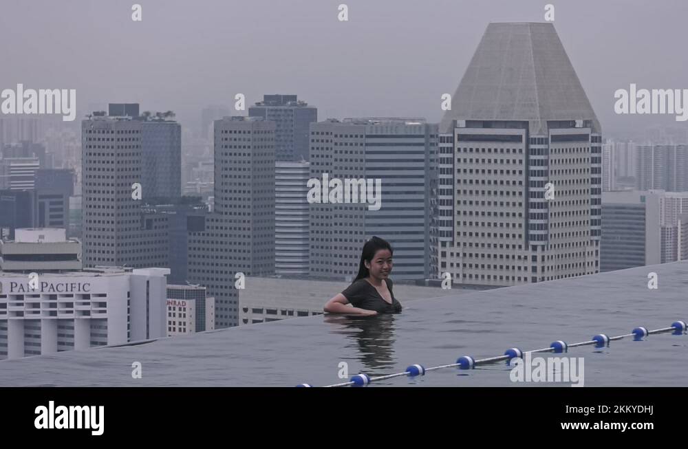 Beautiful Girl leaning on the edge of Marina Bay Sands infinity pool in ...