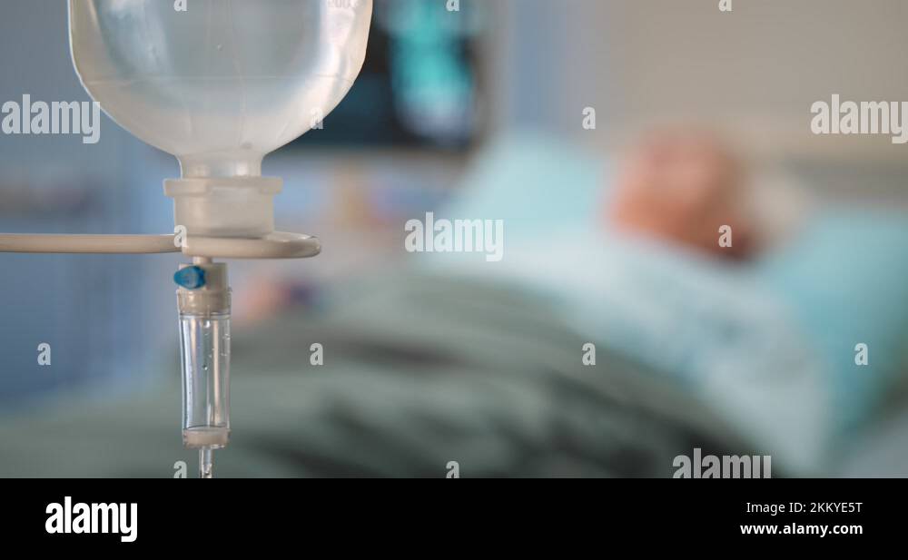 Nurse taking care of sick aged female patient having medication dropper ...