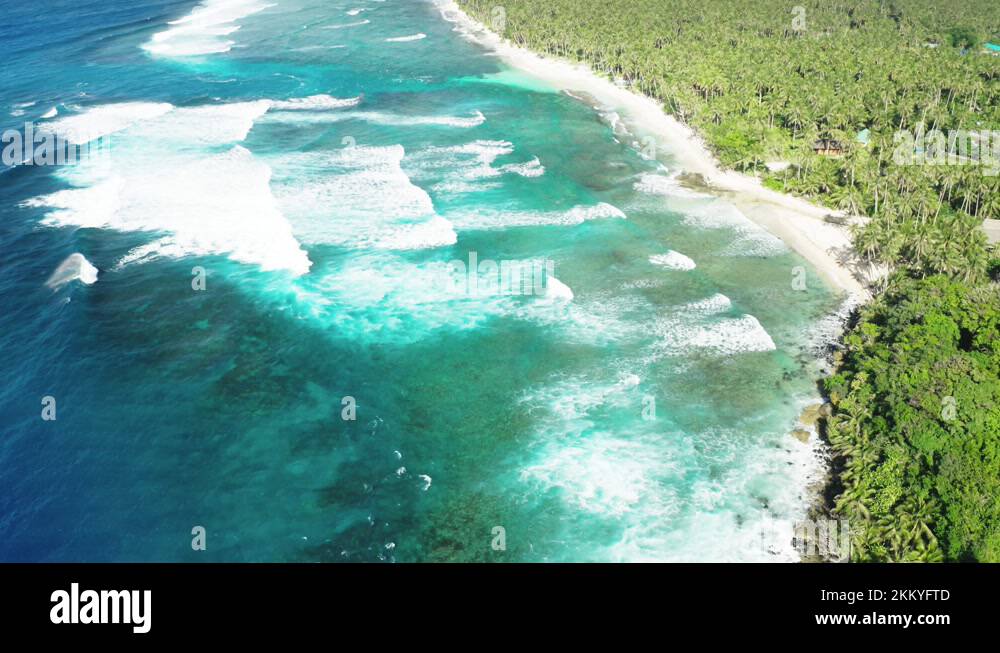 Aerial reveal of coast line of Siargao Island, Philippines. Long waves ...