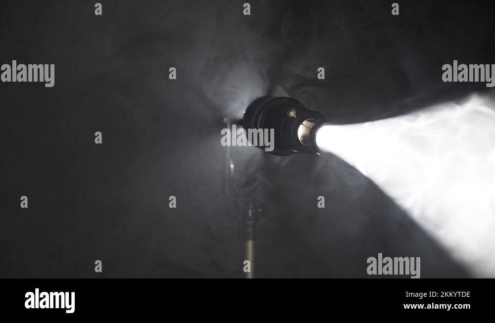 Floodlight beam turns slowly and flares the screen. Stage spotlights ...