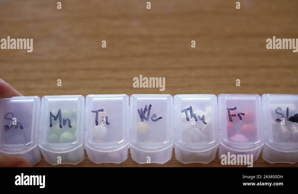 close up of male hand fingers marks cells with black marker for days of ...