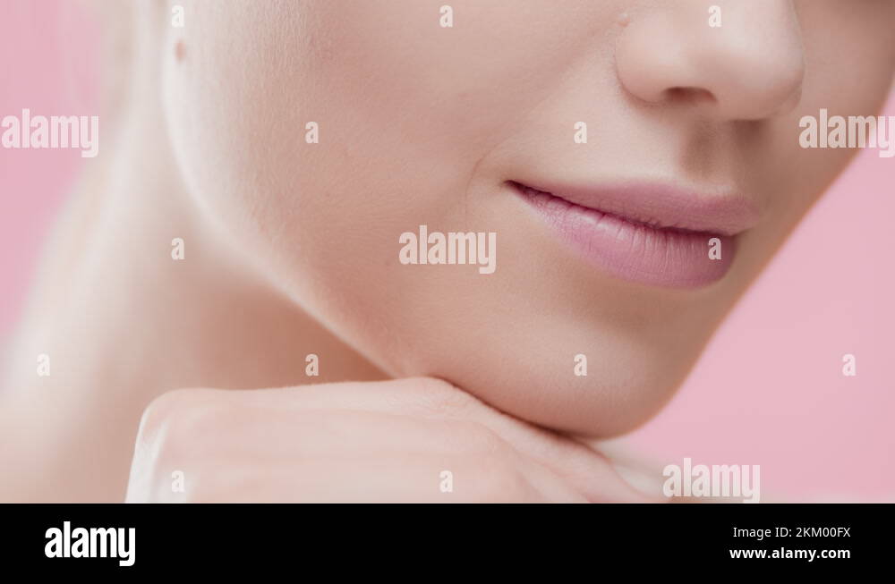 Female skincare model touches her jawline smiling for the camera Stock ...