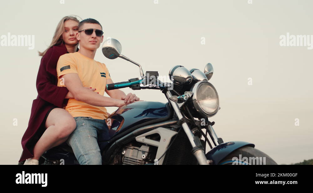 Romantic couple, sit on a motorcycle and admire the sunset Stock Video ...