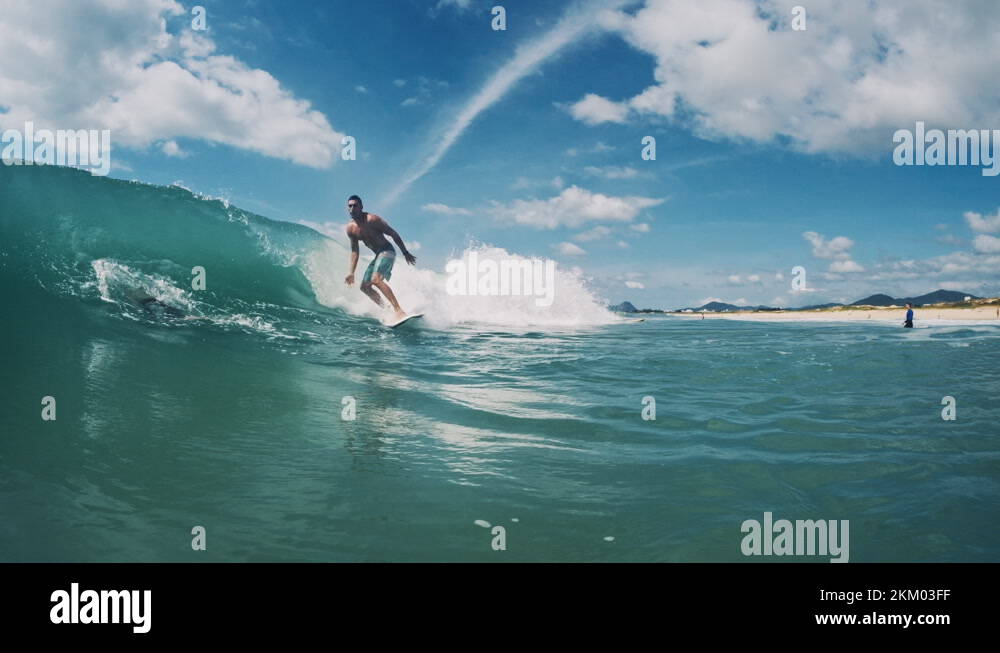 Brazilian surfer. Adult male surfer rides the ocean wave at Campeche ...