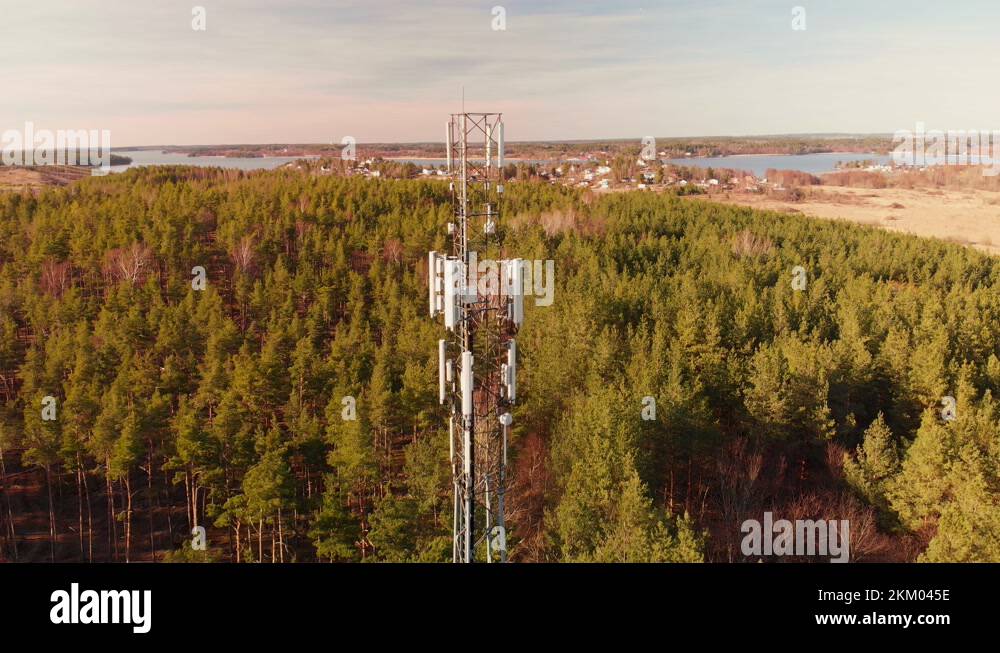 Mobile phone tower in rural area with trees. Aerial dolly in and ...