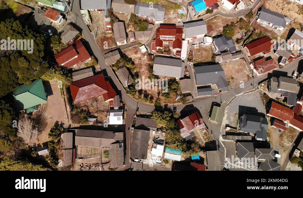 Overhead top down aerial flight over small Japanese village with houses ...