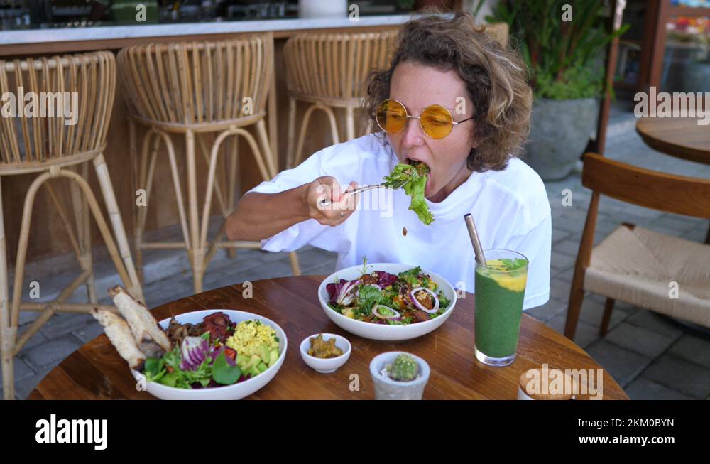 Girl eating her lunch alone in an outdoor sitting area. Having lunch by ...
