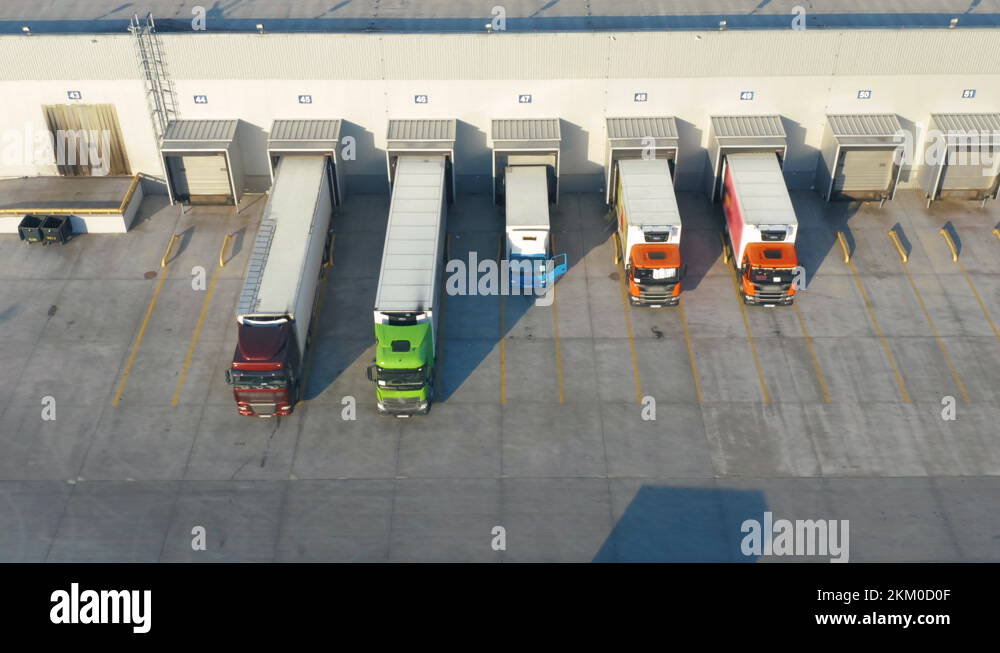 Semi-trailers trucks stand at warehouse ramps for load and unload goods ...