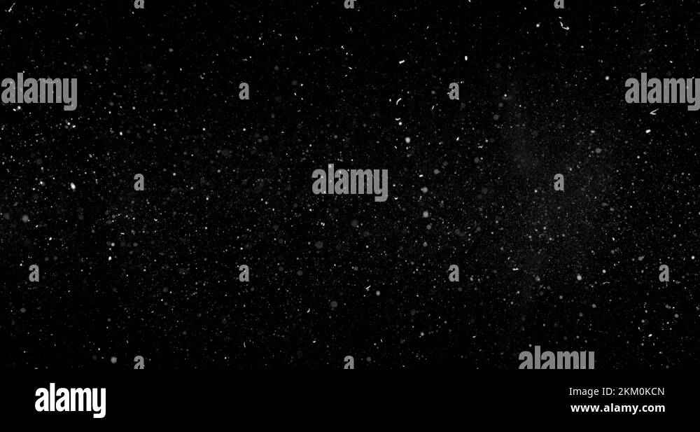 Various dust elements slowly flying around on black studio background ...