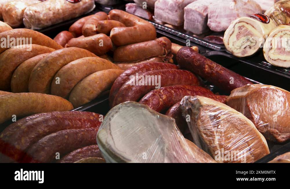 smoked sausage and meat on display case in butcher shop or supermarket ...