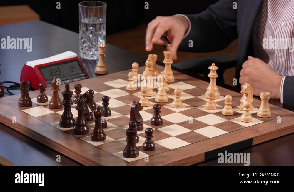 Two unrecognizable people play chess game and one is castling the king ...
