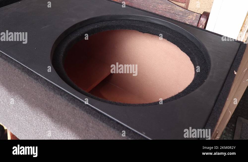 An empty subwoofer speaker box made out of wood with black leather ...