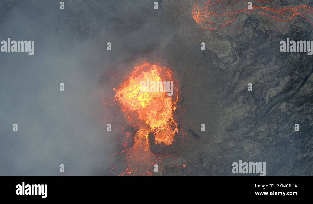 Aerial top down view over active, hot and continuous volcanic eruption ...