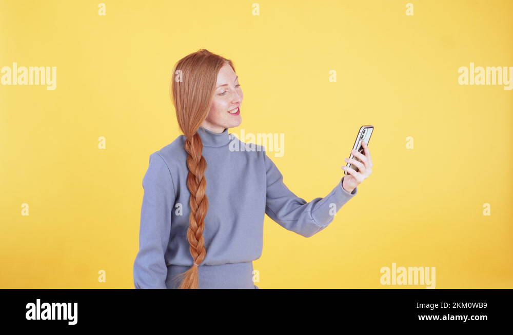 Young woman with freckles and long ginger plait talks to someone on the phone Stock Video ...