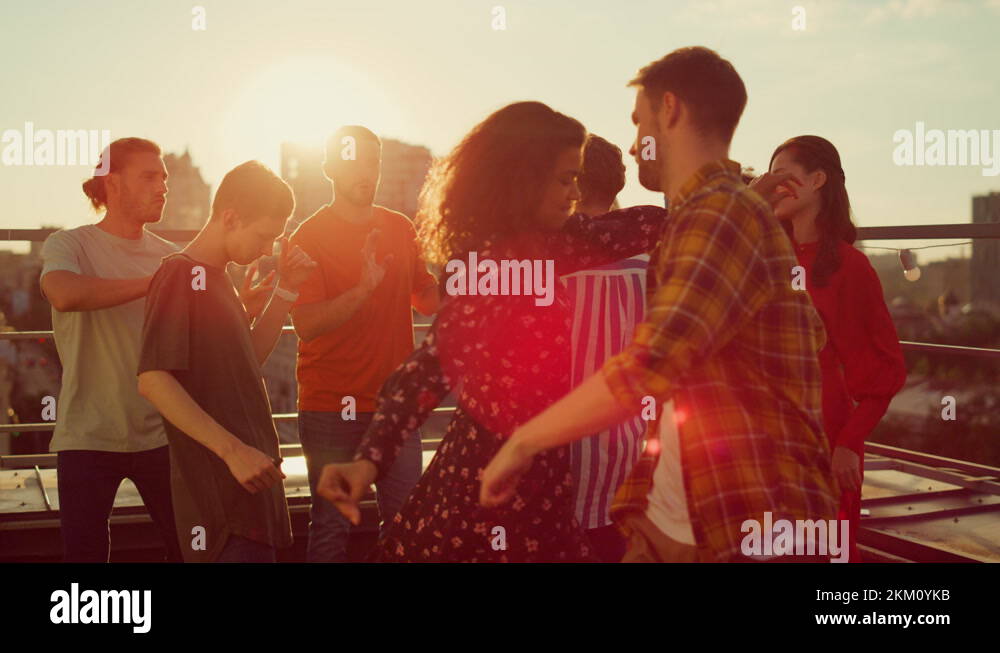 Multiracial couple dancing at roof party. People having fun at open air ...