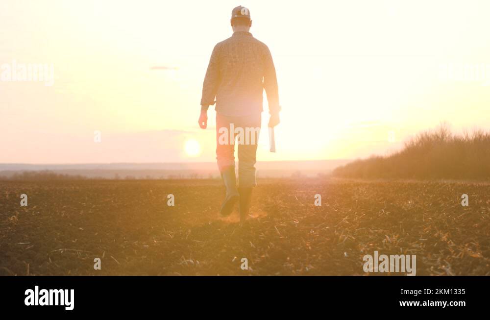 agriculture. smart farming technology. farmer walk feet in boots with ...