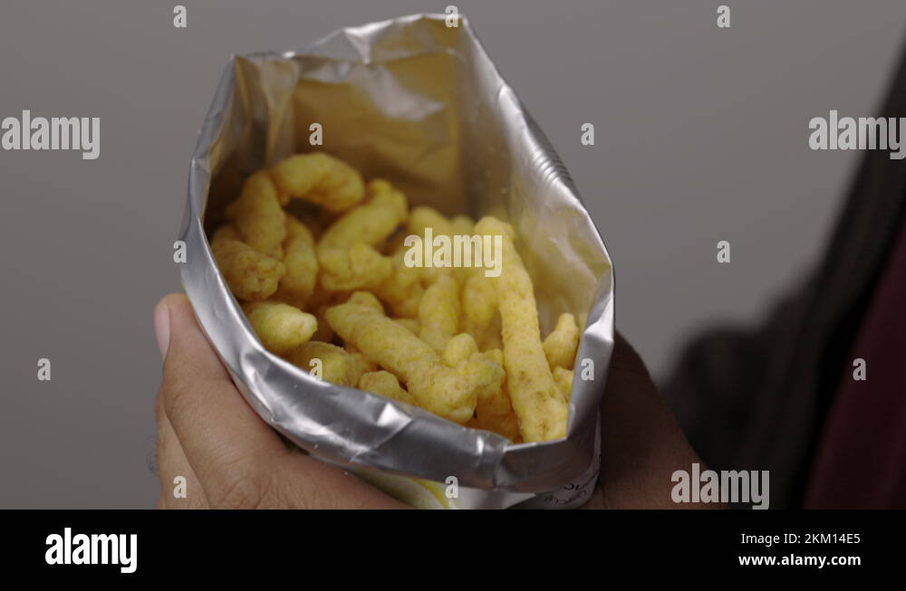 Close up Young man eating Crispy Fried Crunchy cheese salty snacks in ...