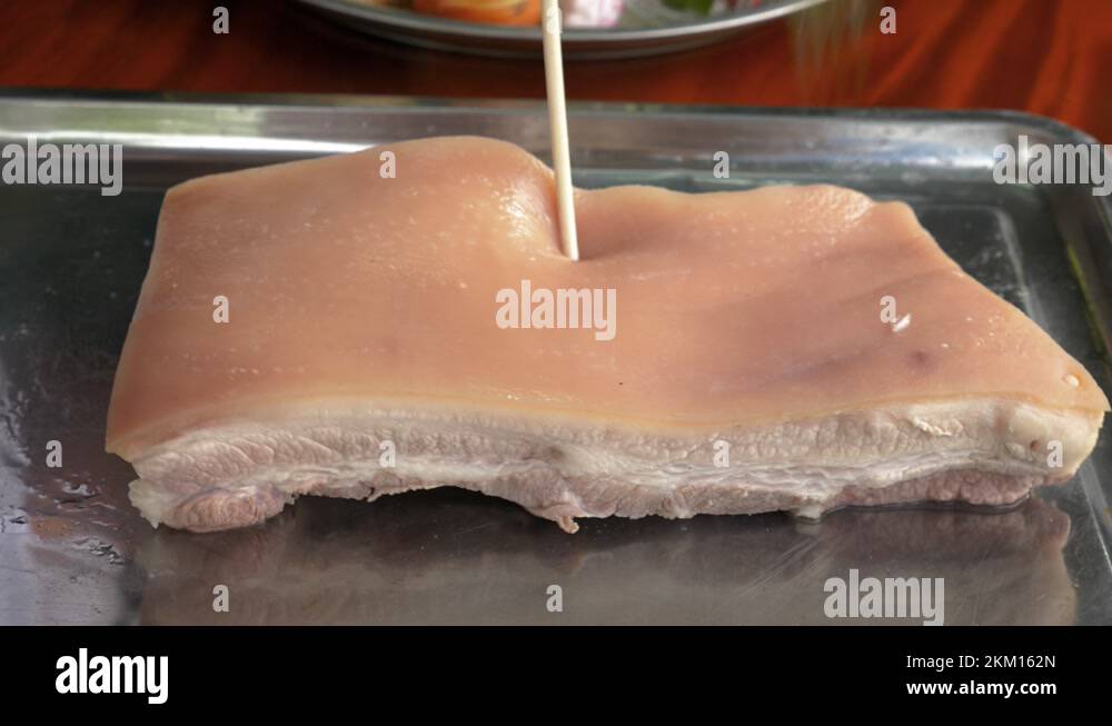 Stabbing freshly boiled pork belly meat with fork, Thai traditional ...