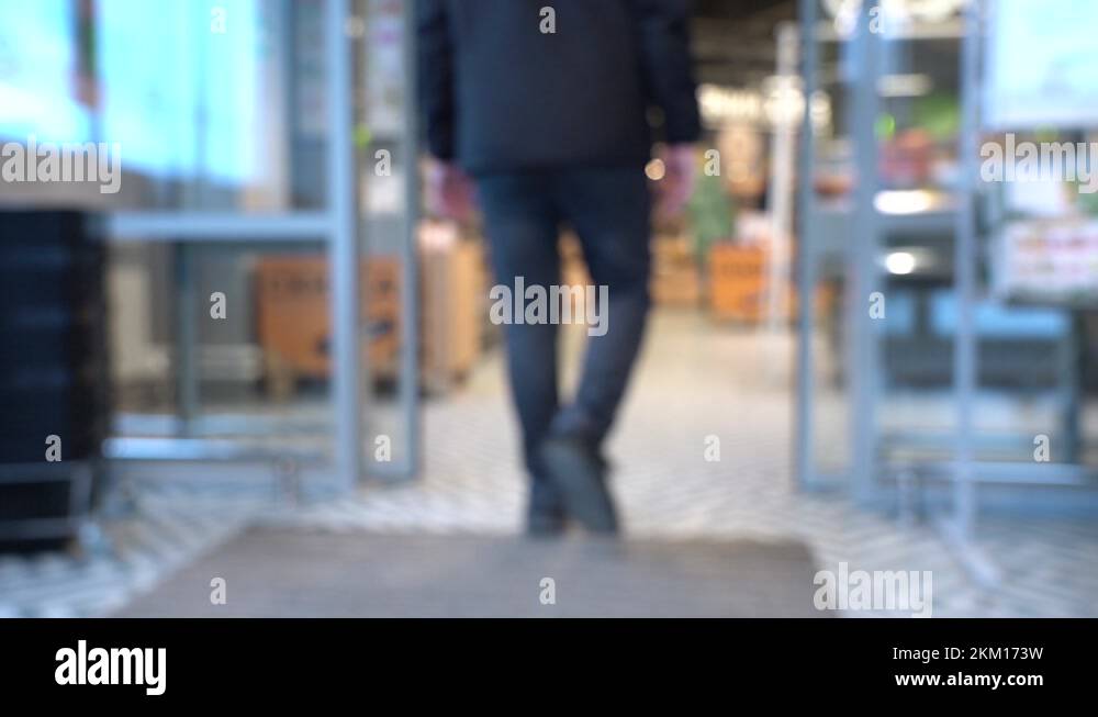 A young man enters the supermarket through the self-sliding doors Stock ...