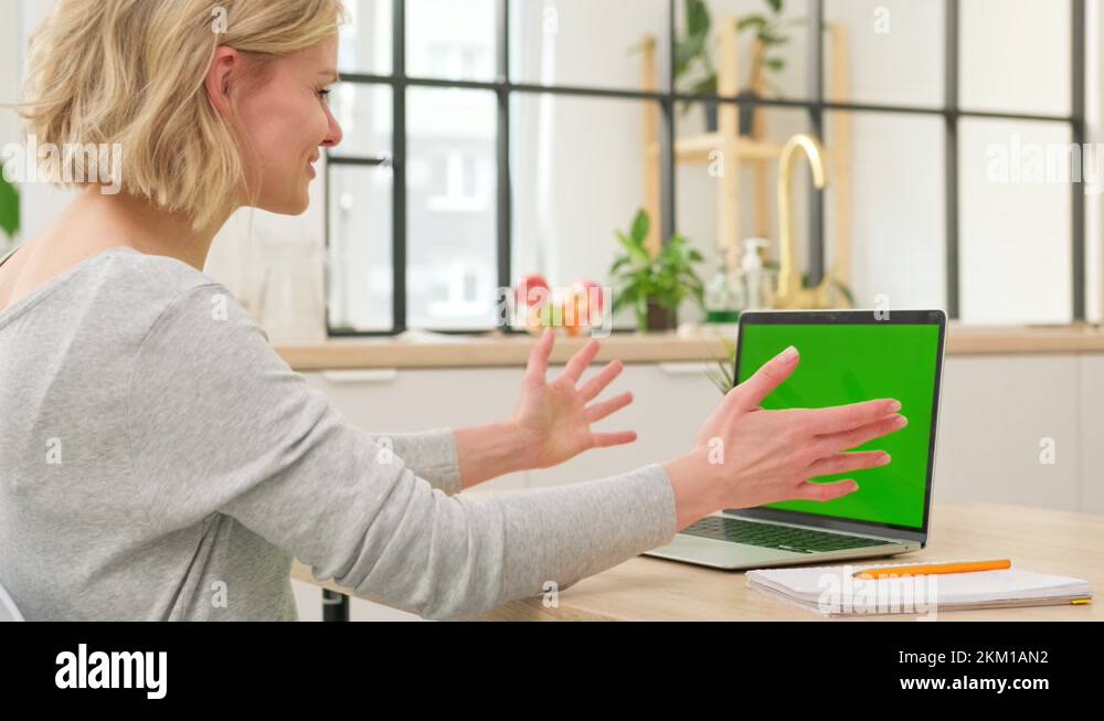 Pretty girl calls video conference on laptop, gestures with her hands ...