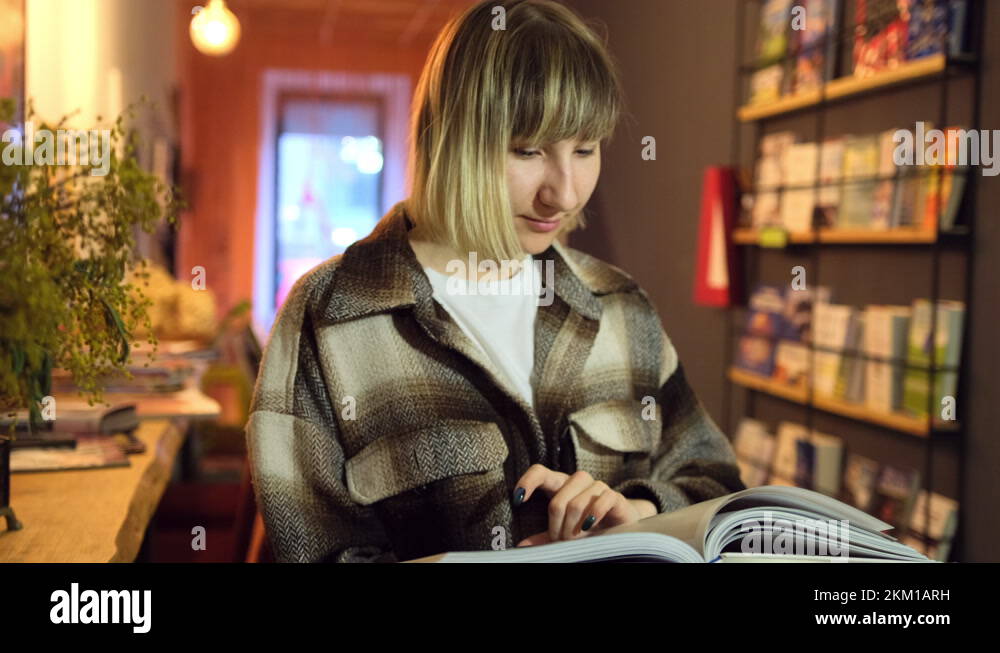 Woman reading book in library. Portrait college lady flips pages ...