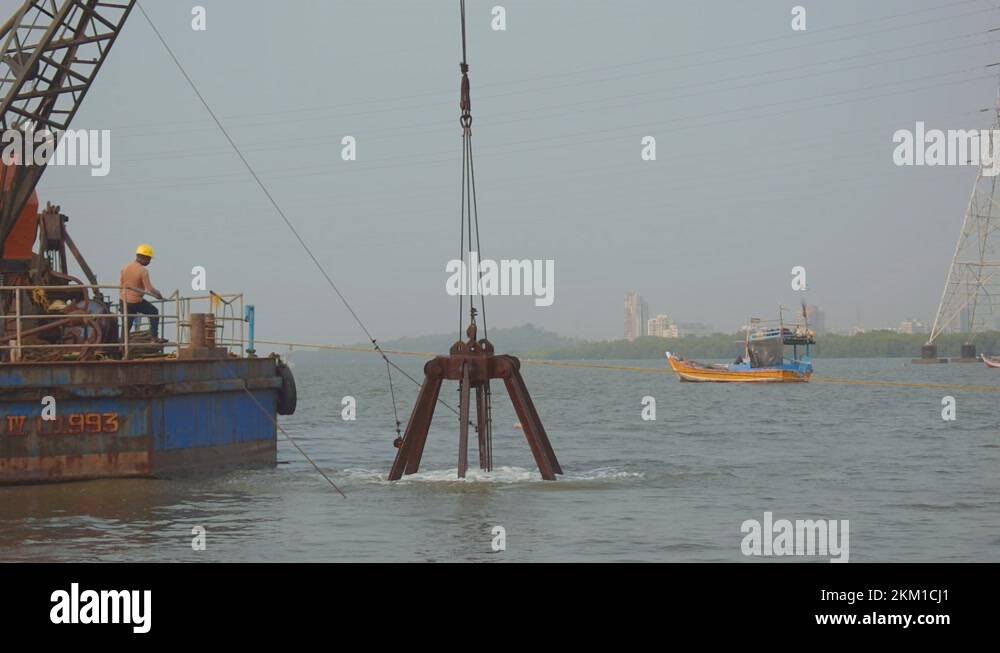 Mining or cleaning ocean or bay with a huge crane digging anchor in ...