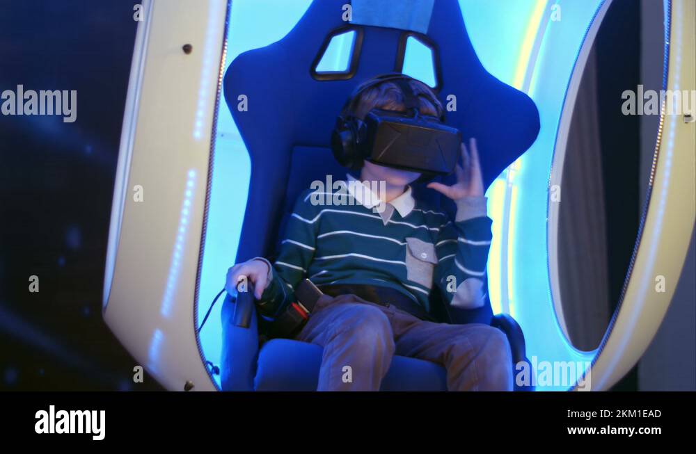 Surprised little boy experiencing virtual reality in a moving ...
