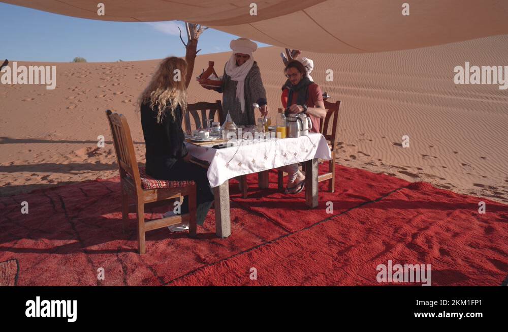 Moroccan Men Serving Breakfast To Romantic Couple Under A Tent In ...