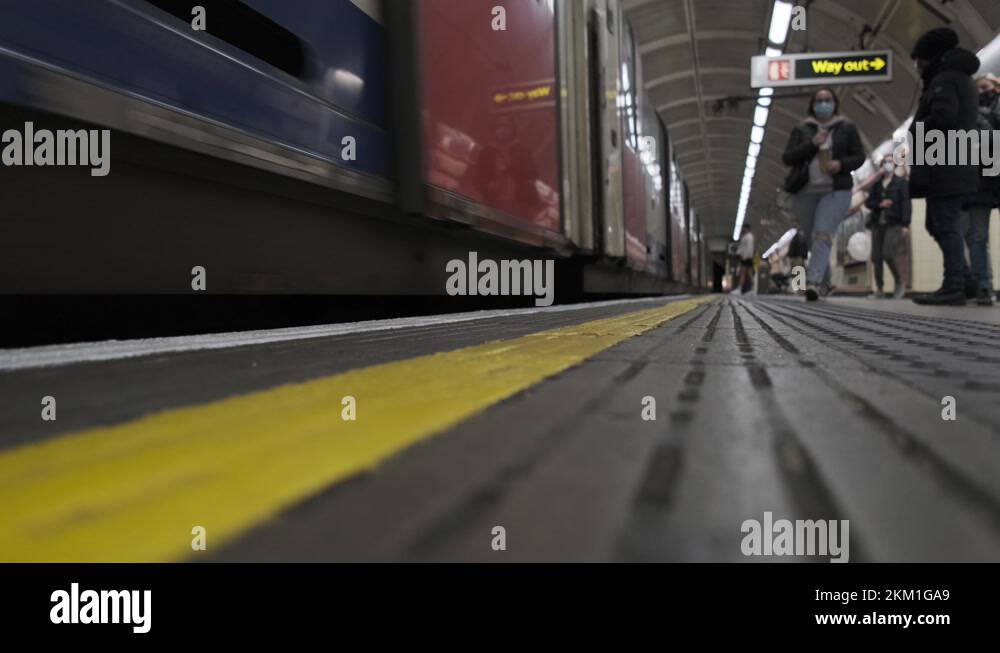 Central line london underground train pulling into station low angle ...
