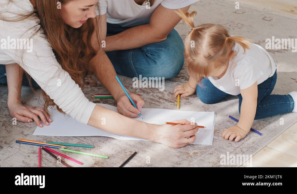 Caucasian family draws together at home, young caring loving parents ...
