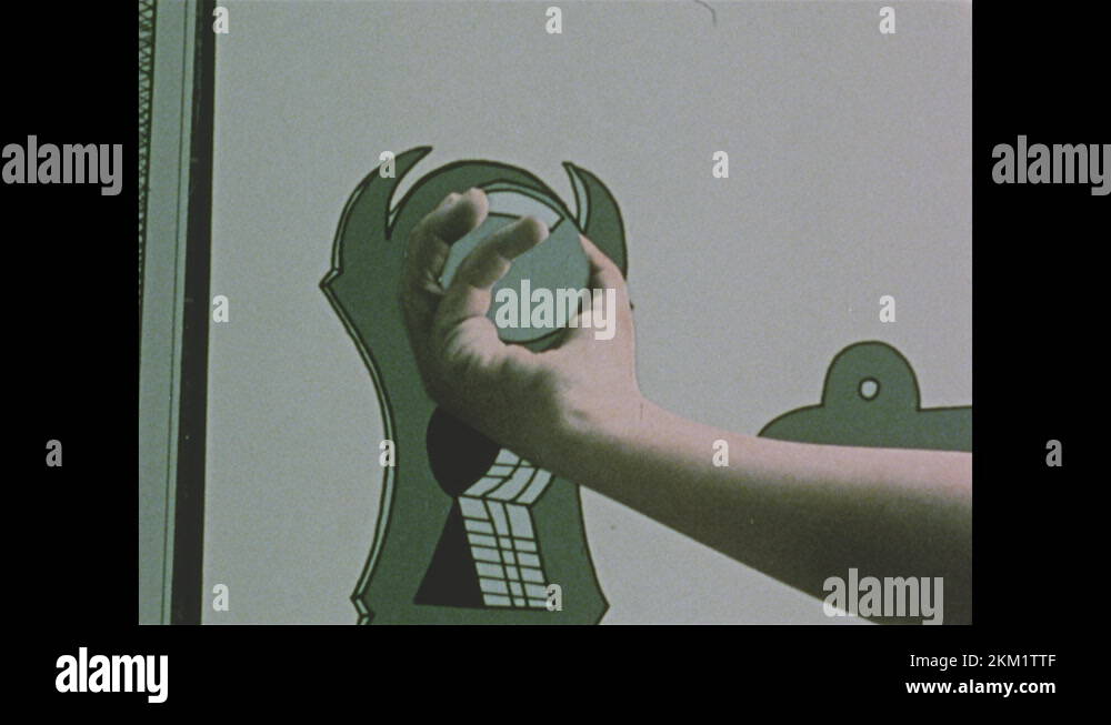 1970s: Keyhole. Girl looks through keyhole. Girl opens door, looks ...