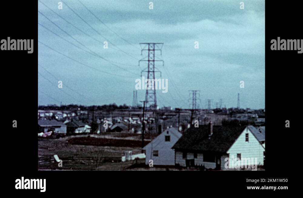 1950s: Transmission towers and power lines. Two workers in small ...