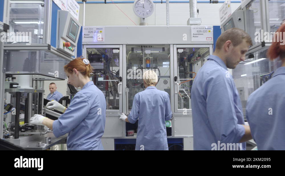 Factory Workers Assembling Rotors for Cars on an Assembly Line: Dolly ...