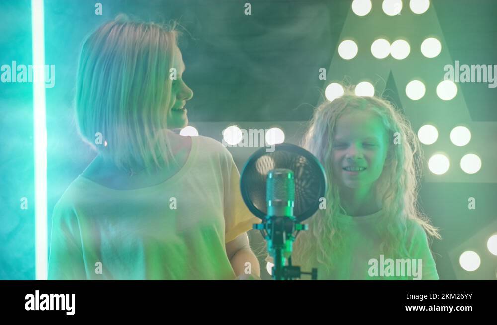 Mom And Daughter Are Engaged In Singing Into Microphone In Karaoke Club
