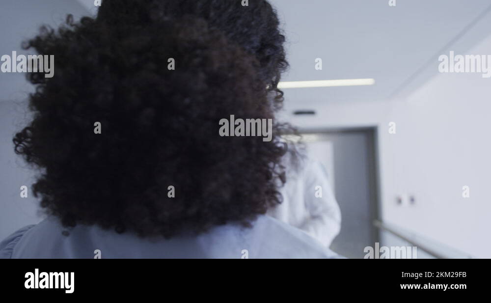 African american male and female senior doctors talking to each other ...