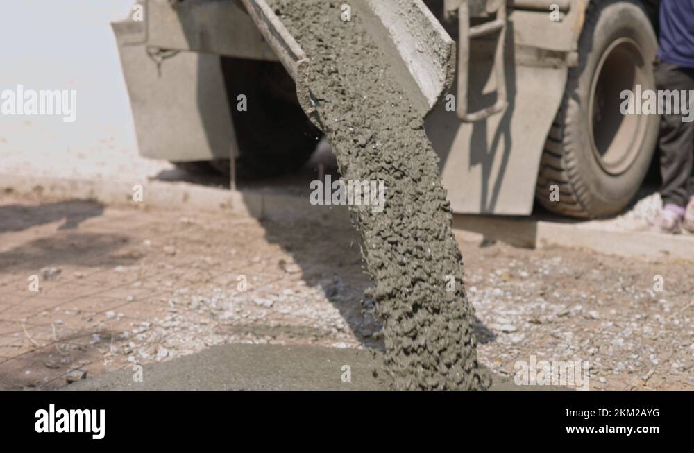Concrete flowing and pouring from mixer cement truck pours liquid ...