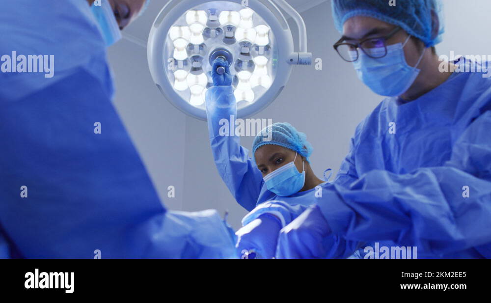 Asian surgeon wearing surgical cap and face mask operating in hospital ...