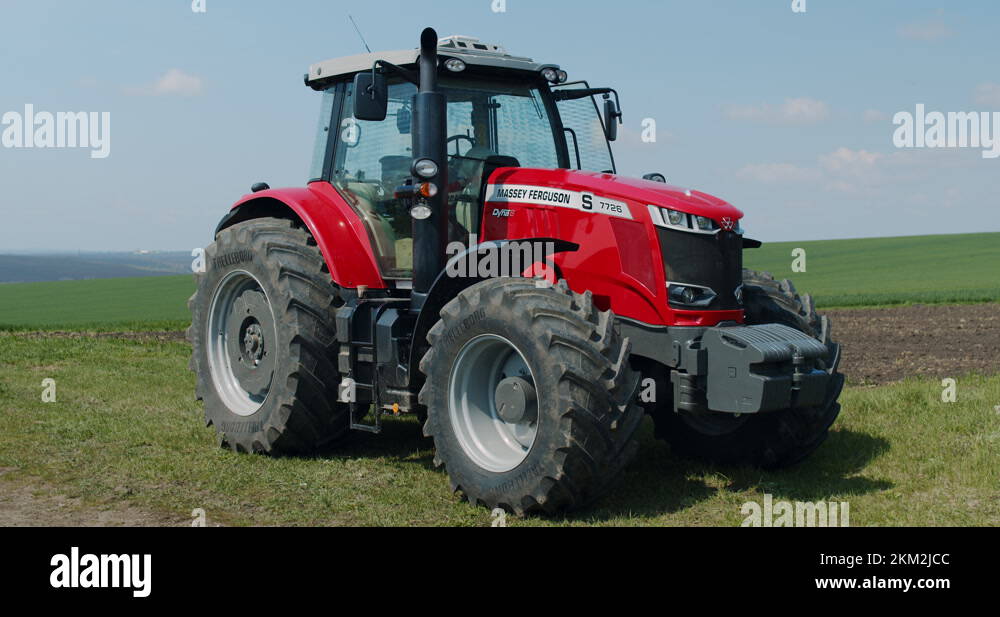 A modern red tractor on an agricultural field. Agricultural technique ...