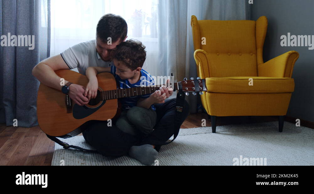 Dad sings a song, a guitar song with his youngest son Stock Video ...