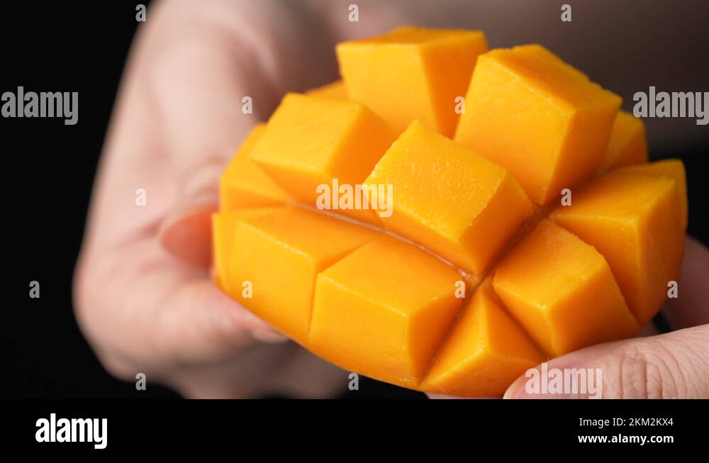 Slow motion of cutting fresh mango fruit and showing the juicy diced ...