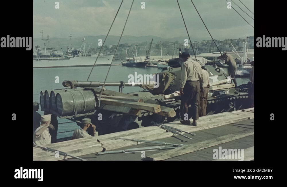 1960s: Tank lowered onto deck of ship. Tanks on dock. Tank navigates ...