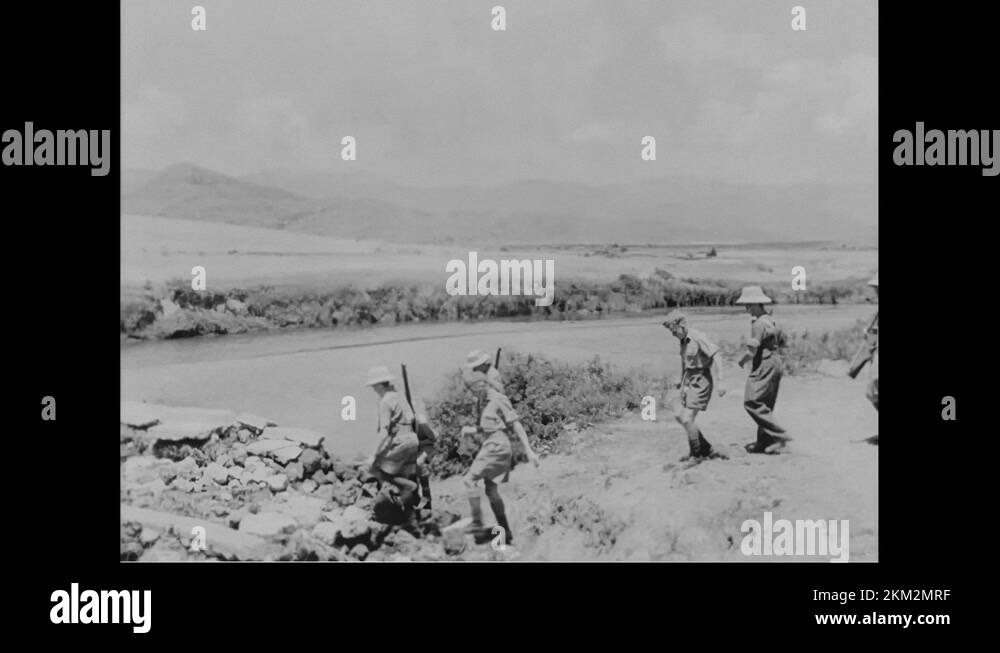 1940s: Soldier with rifle paces in front of train. Men with guns walk ...