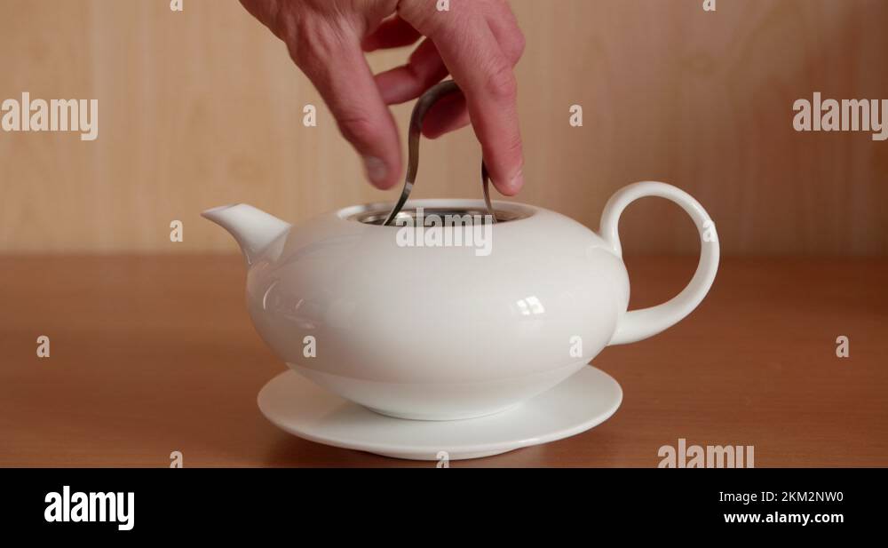 Porcelain teapot filled with boiling water ready to serve fresh tea ...