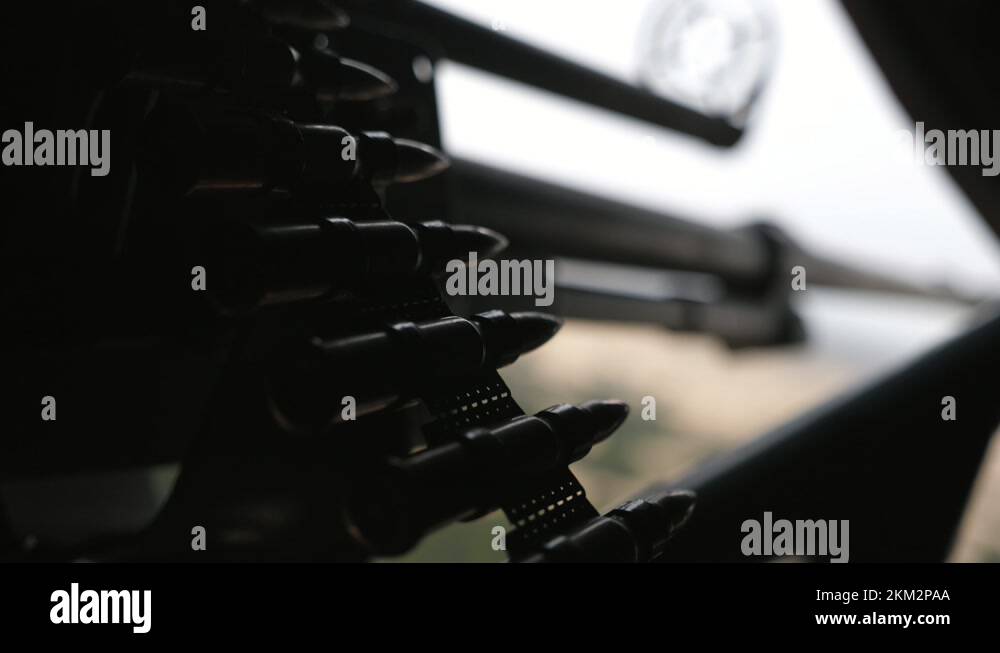 Modern cartridge tape with bullets installed on a machine gun in a ...